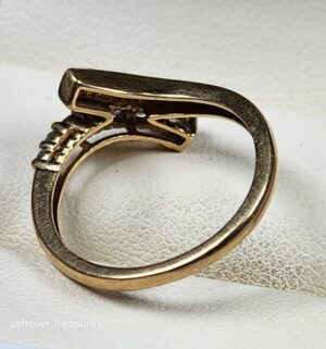 c154- 10k yellow gold bypass band featuring a channel-set row of clear ...